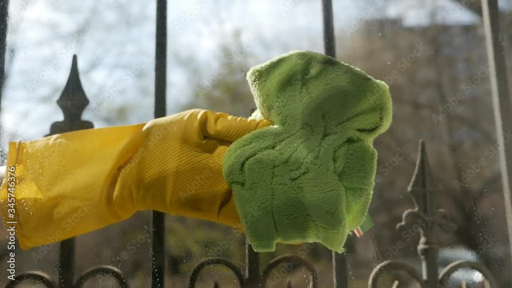 A female hand is washing a window with a rag. Home cleaning, restoring ...