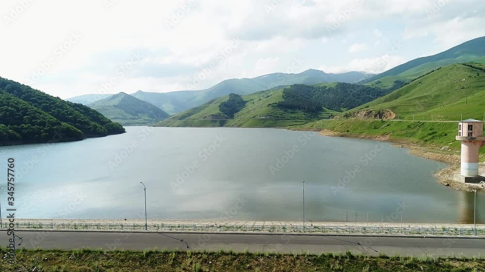Aerial view opening up to a wide river between two mountains covered by ...