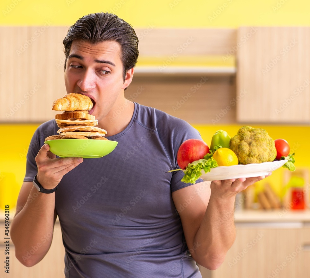 Man having hard choice between healthy and unhealthy food Stock Photo ...