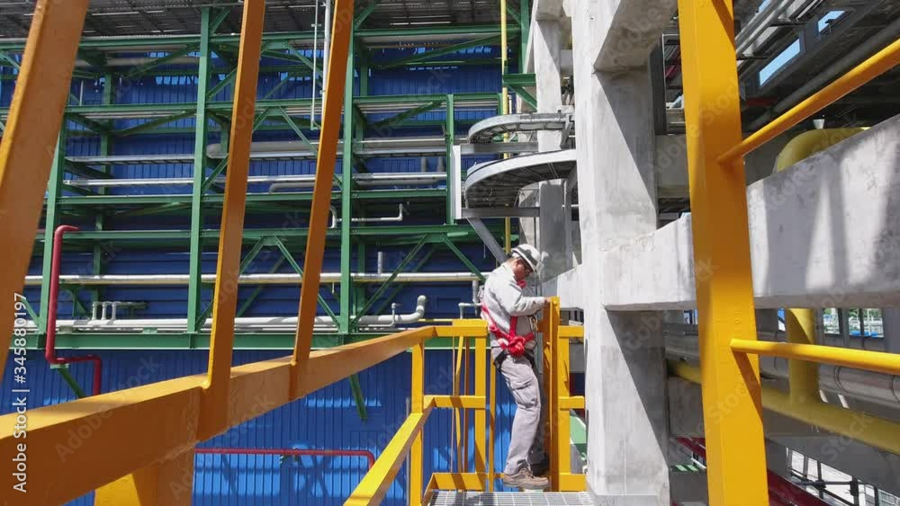 Vidéo Stock Engineers wear a full body safety harness and climb up the ...