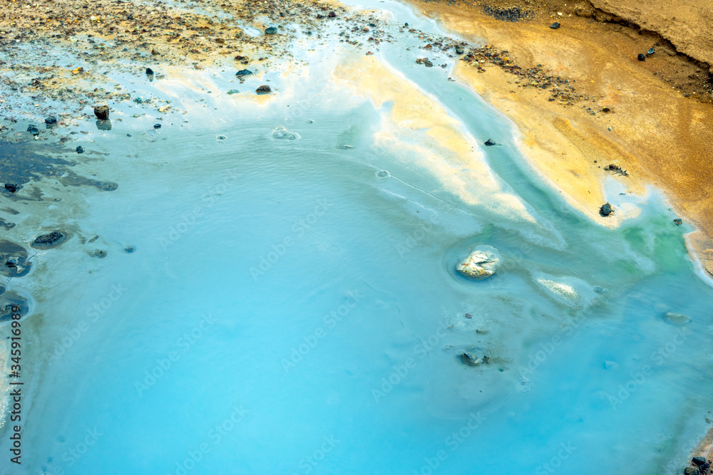Multi colored bubbling hot pool and colorful soil , rocks and dirt in ...