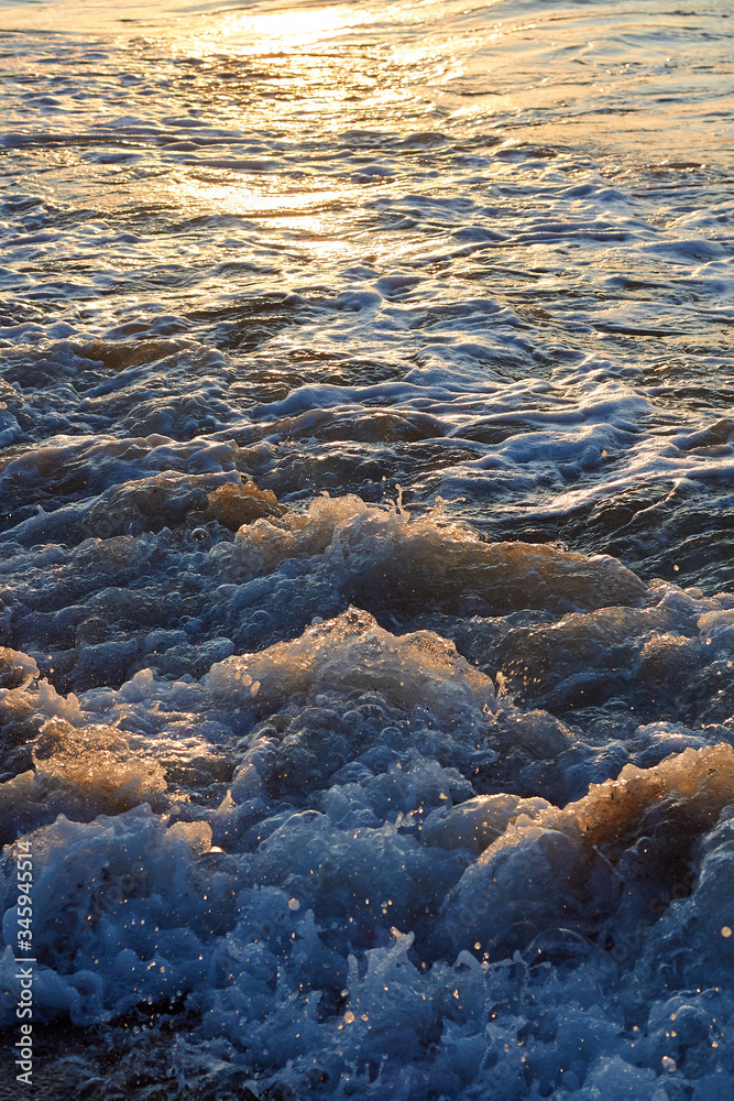 Beautiful sea waves with a lot of sea foam splash on the sandy shore ...