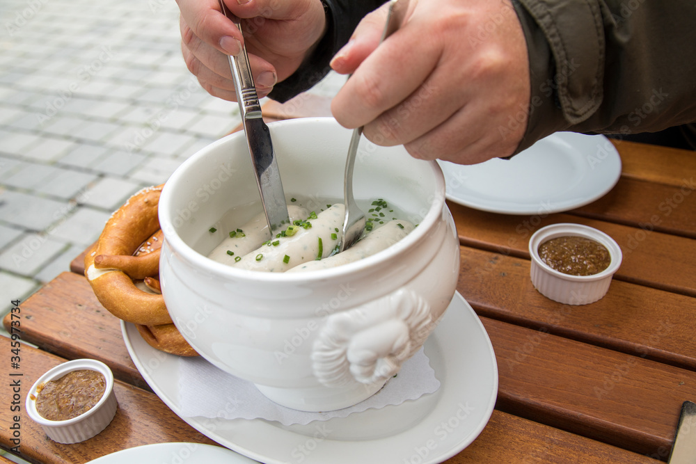 Mann isst Münchener Weißwurst mit Messer und Gabel, süßen Senf und ...
