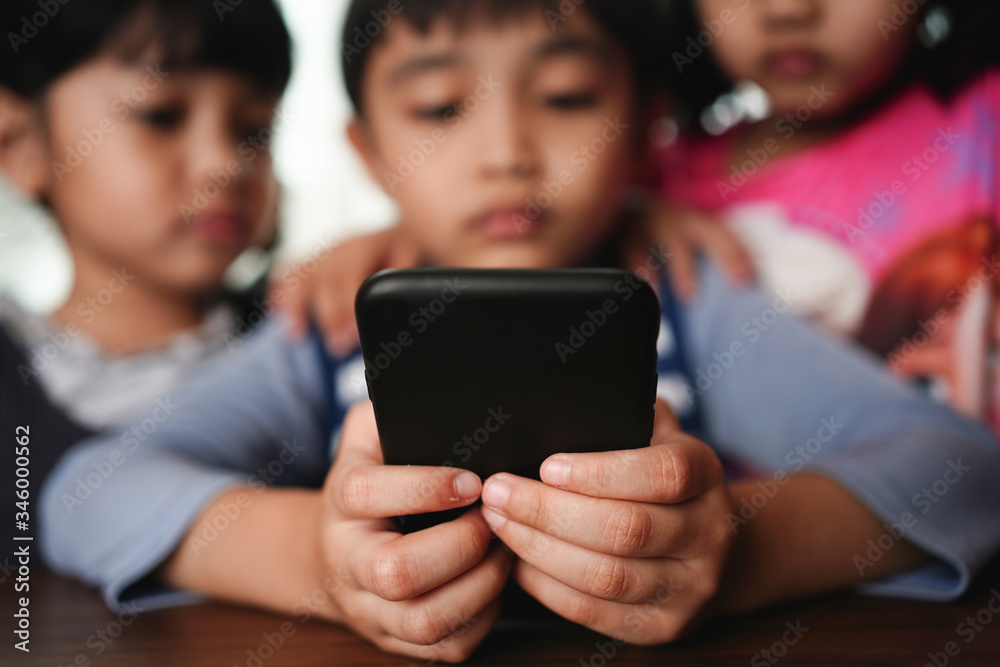 Asian children playing a smart phone, Smart phone has a negative impact ...