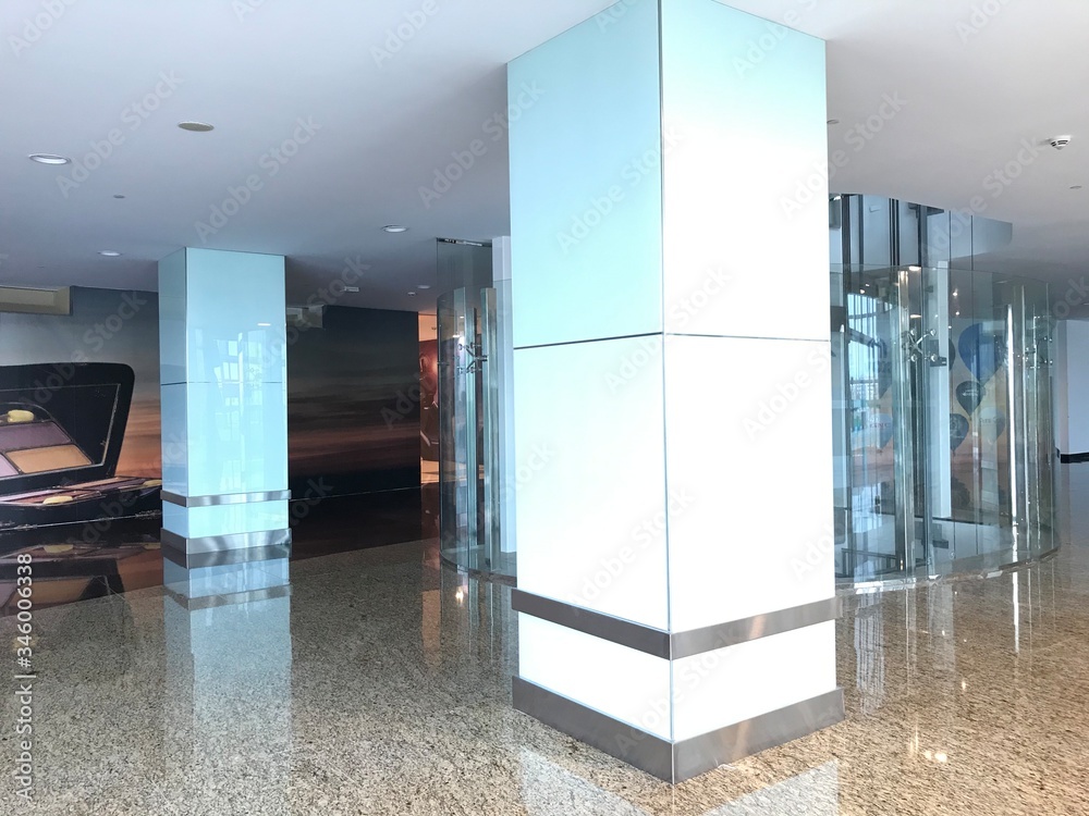 Columns with transparent glass cladding and stainless steel skirting ...