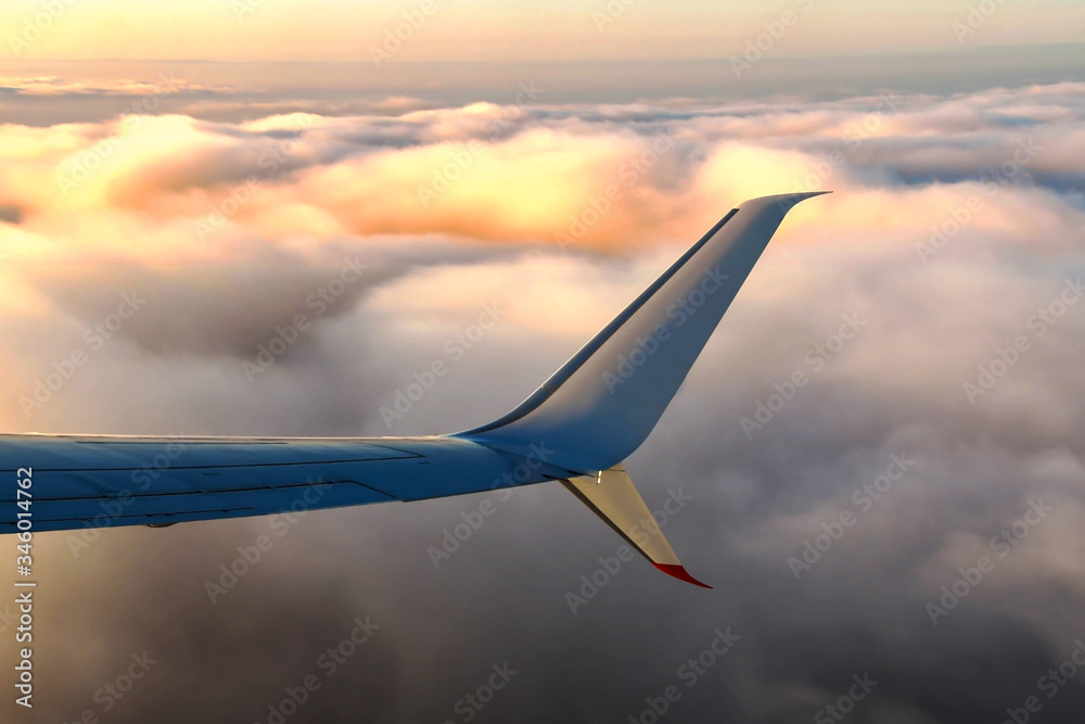Curved wing tip of a modern passenger jet against clouds in early ...