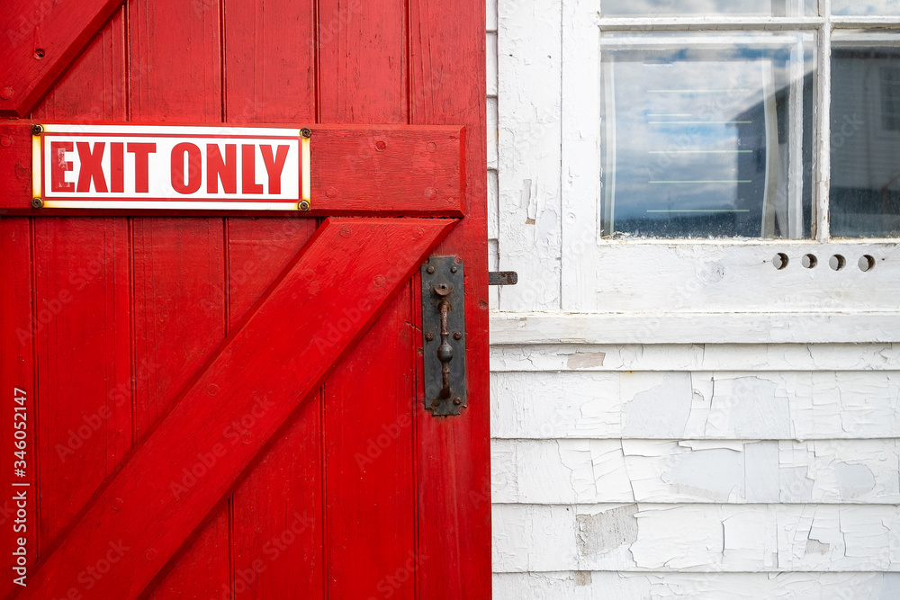 Exit only sign with red letters on a white background. The sign is ...