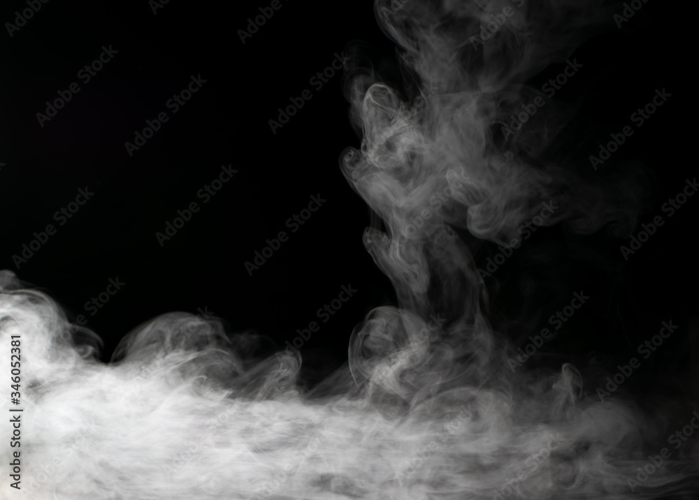 White puffs of smoke on a black background float mixing in bizarre ...