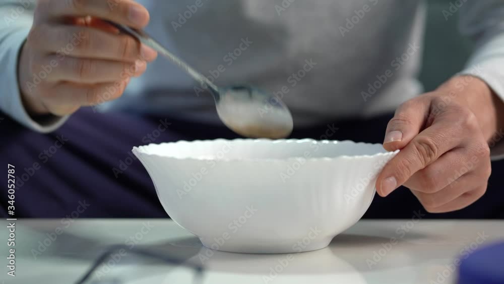 Close up on midsection of unknown caucasian man hand holding the spoon ...