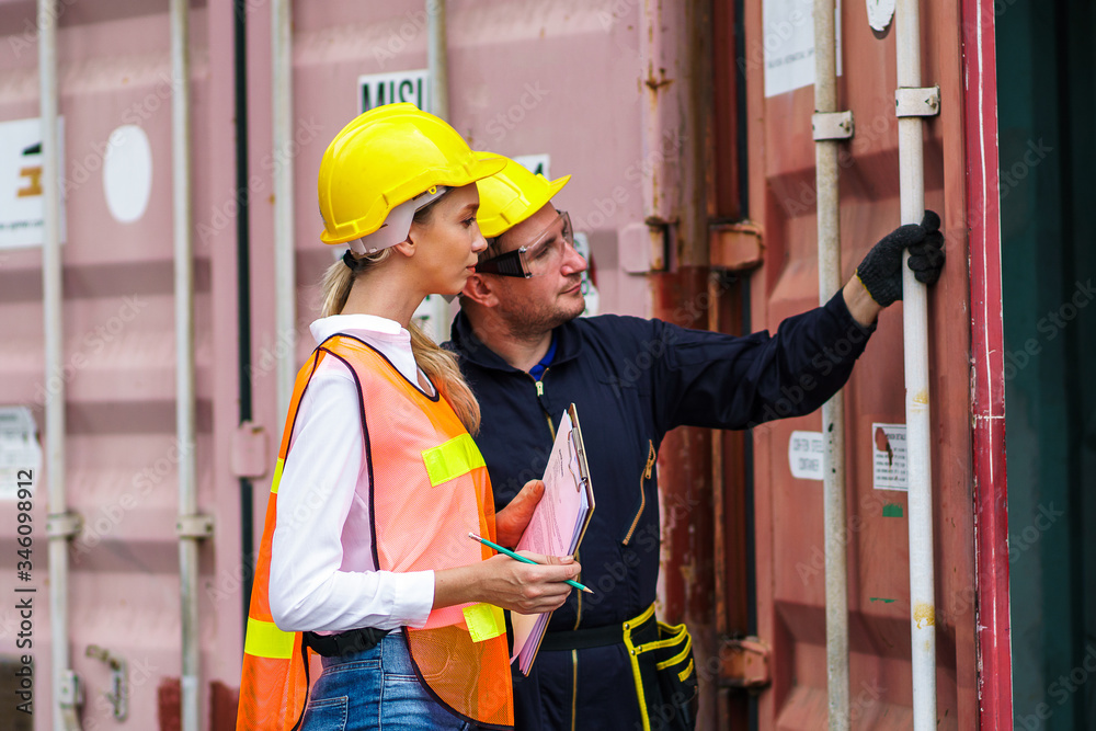 Dock worker team wearing a yellow helmet standing in a industrial ...