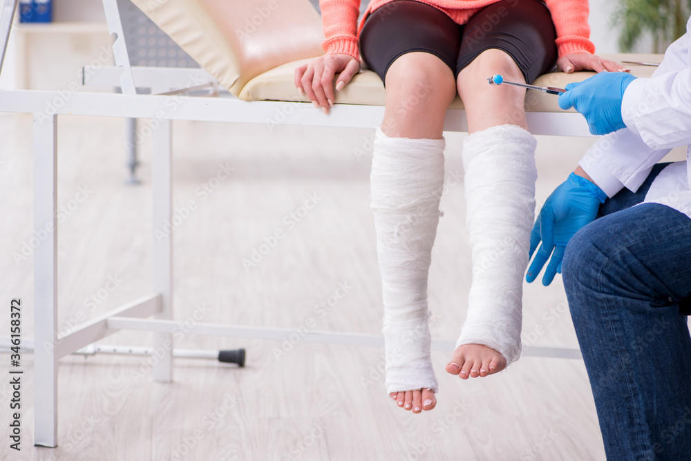 Young leg injured woman visiting old doctor traumatologist Stock Photo ...