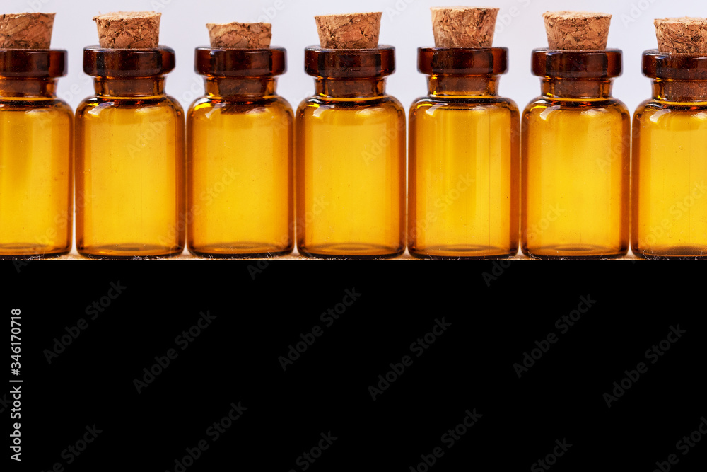 Amber-colored pharmaceutical vials with cork. Close-up. Black ...