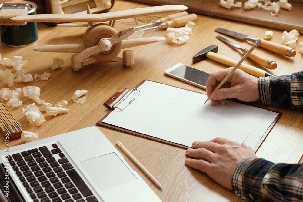 Craftsman designing a DIY project on a clipboard Stock Photo | Adobe Stock