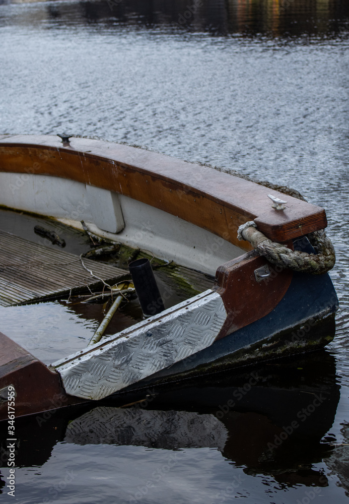 Sinking wooden boat in river canal in the Netherlands, reflection of ...