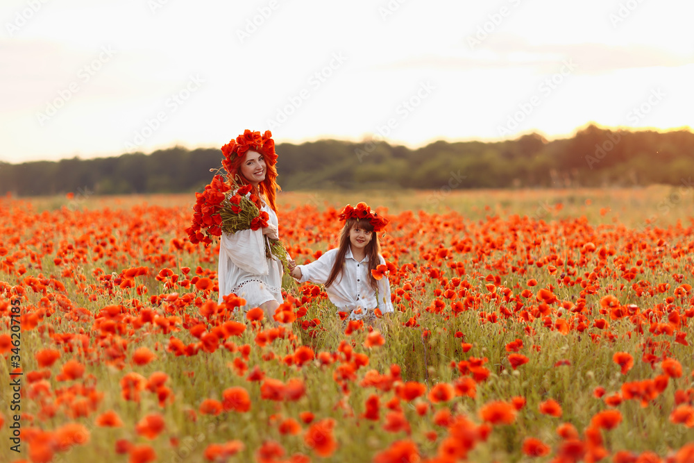 Little girl with redhead mother in white dresses and wreathes walking ...