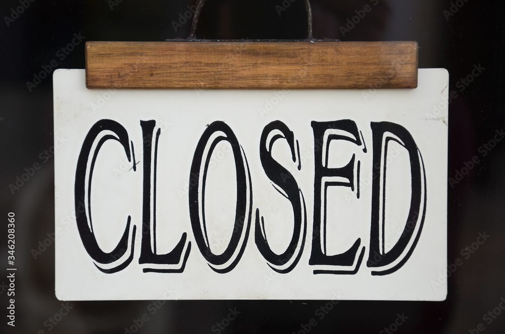 Sign Closed on the front window of a store. Black sign in Western-style ...