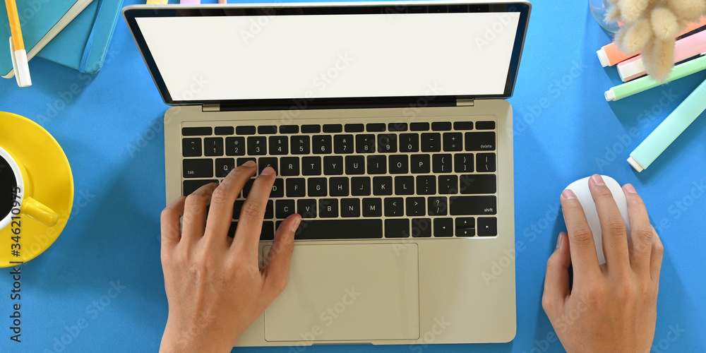 Closeup top view of hands while using mouse and typing on computer ...