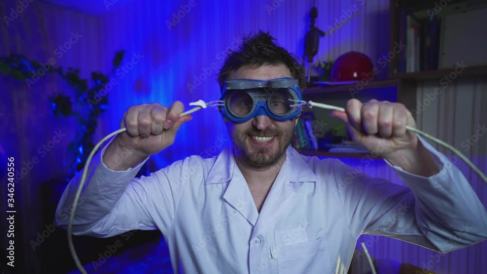 A crazy doctor connects two electrical wires. Hairy nerd with big glasses and a white coat ...