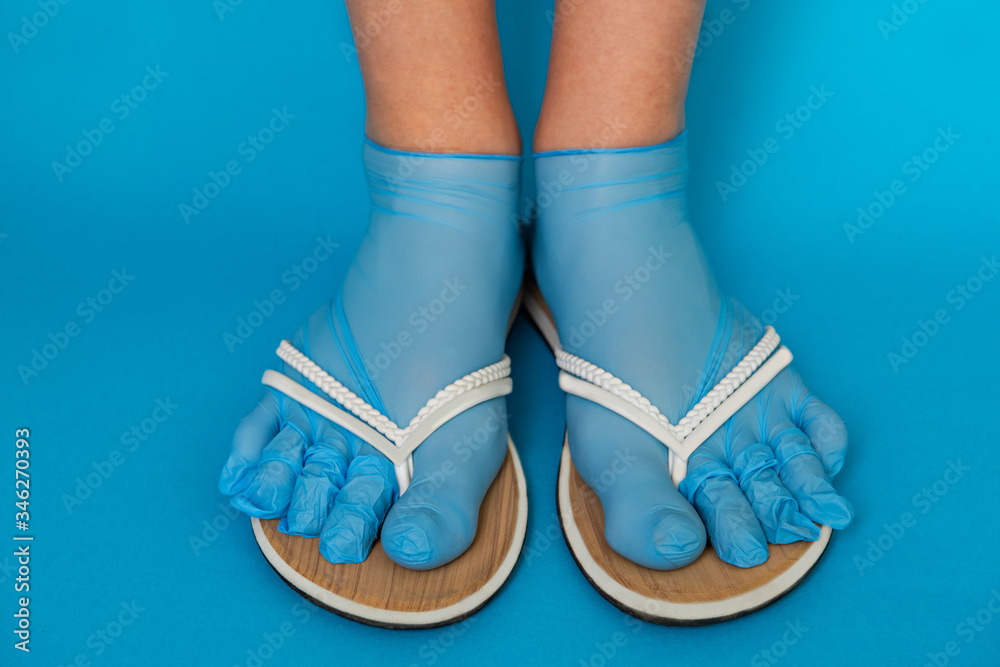 A girl’s feet in sterile disposable gloves dressed as socks and shale ...