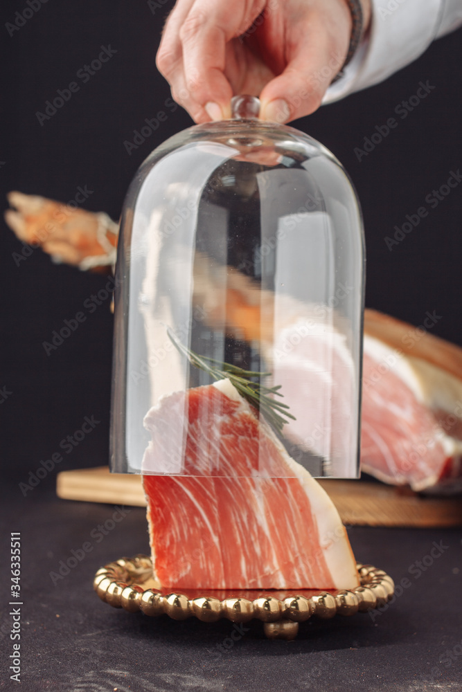 The chef opens a glass cover of meat and rosemary. Traditional spanish ...