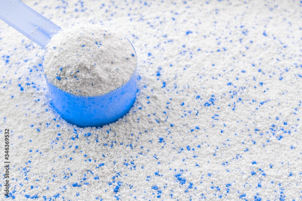 Detergent background. White wash powder with cup for laundry, washing ...