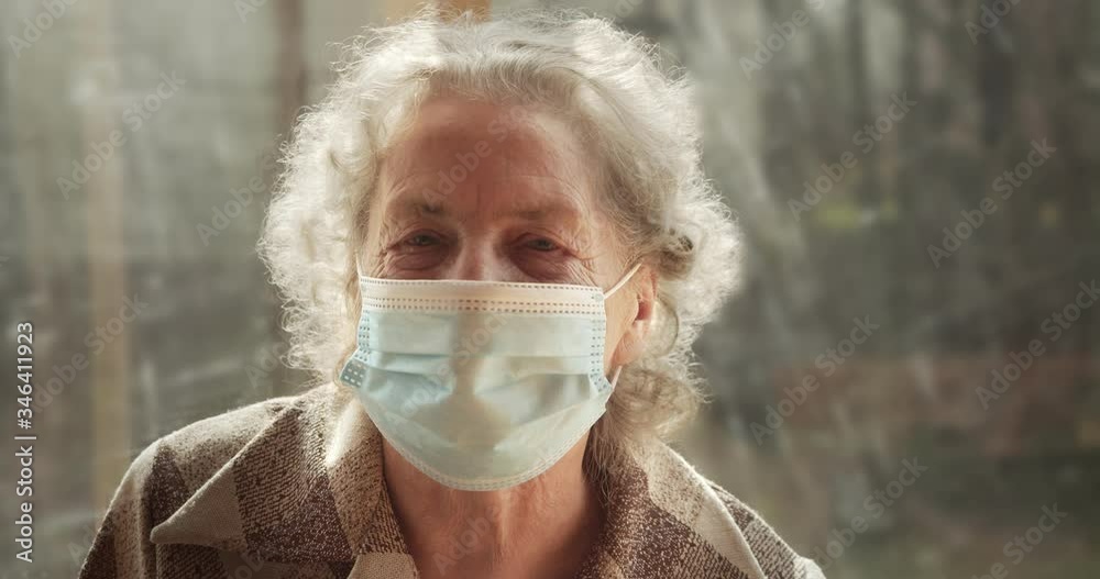 elderly woman in a respirator protection mask is home. Quarantine ...