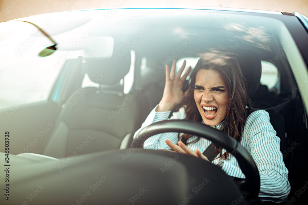 Woman is driving her car very aggressive and gives gesture with her ...