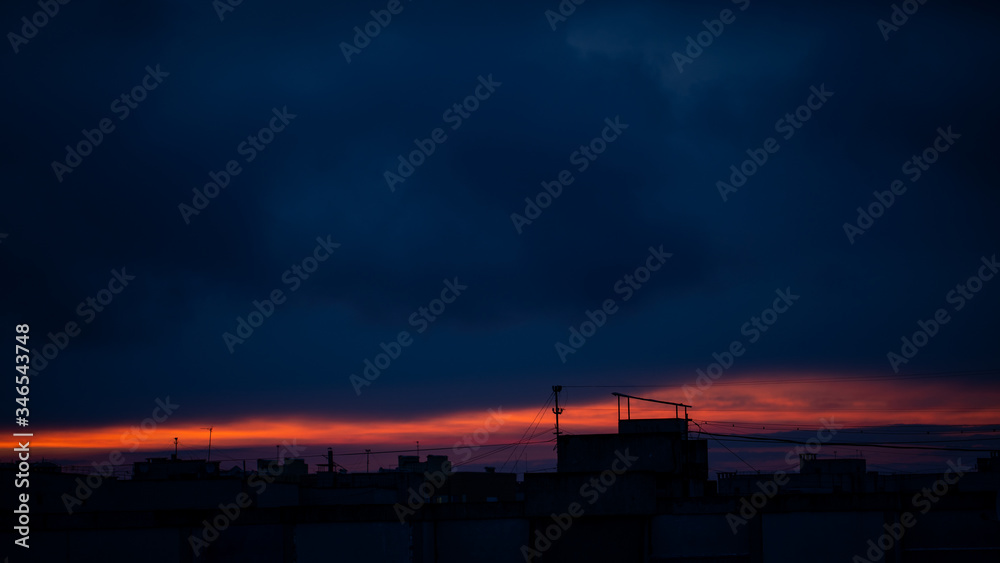 Dramatic dark sunset skyline over roofs of buildings of town. Stock ...