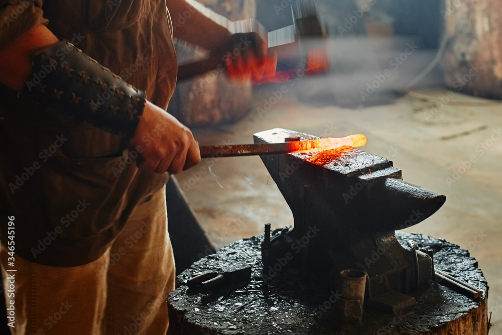 Manual work of a blacksmith in a blacksmith Shop. Hammer blows on the ...