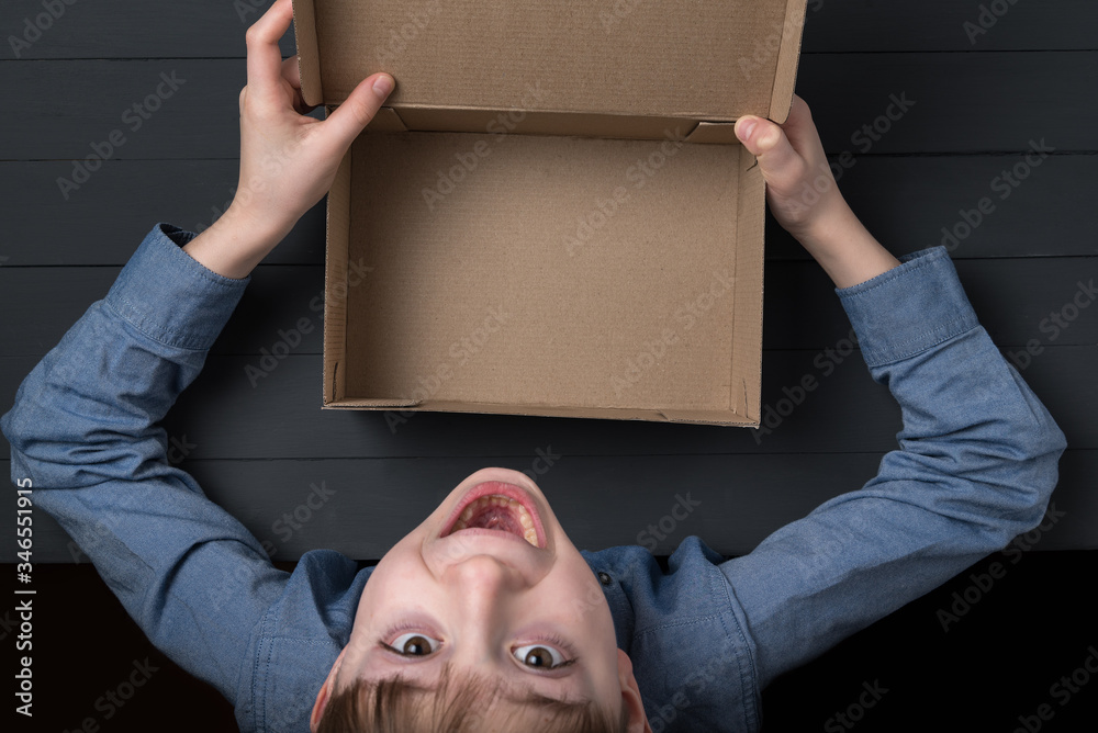 Funny boy with an open empty box. Top view Stock Photo | Adobe Stock