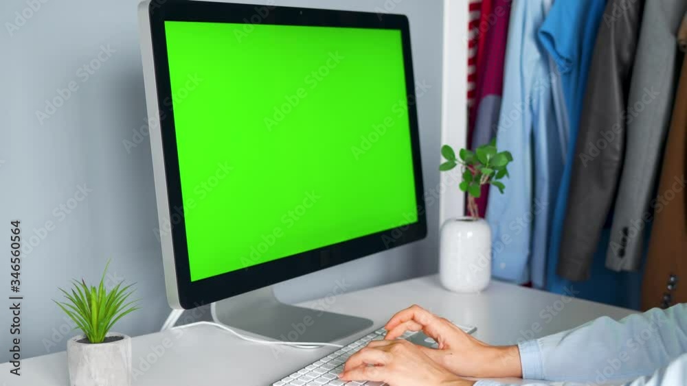 Woman typing on a computer keyboard at home office, monitor with a ...