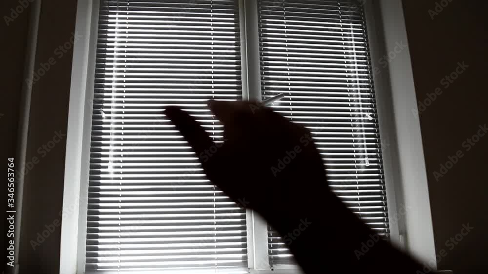 Close-up unfocused silhouette of a man's hand reaching for the light ...
