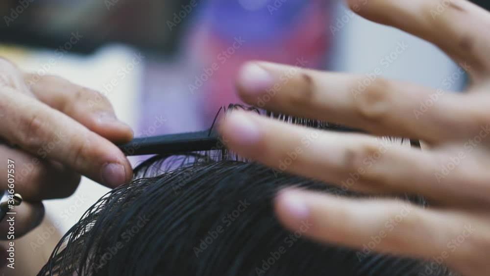 CU, slow motion: young barber does stylish haircut to client with black ...