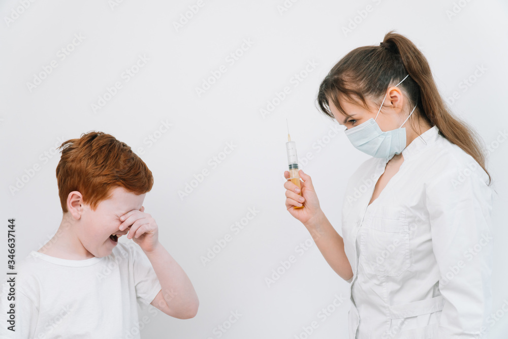 Little boy is afraid of the doctor with a syringe. Baby cries afraid ...