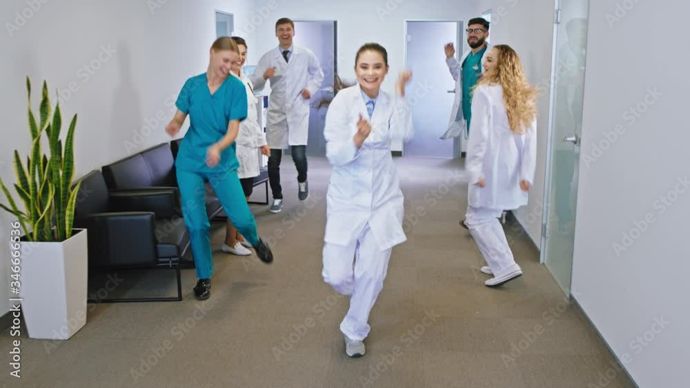 Good looking group of doctors and nurses dancing in front of the camera ...