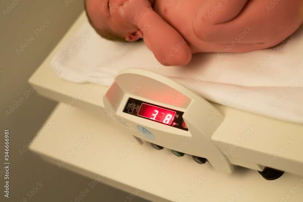 Newborn baby at hospital is getting measured and weight in hospital and ...