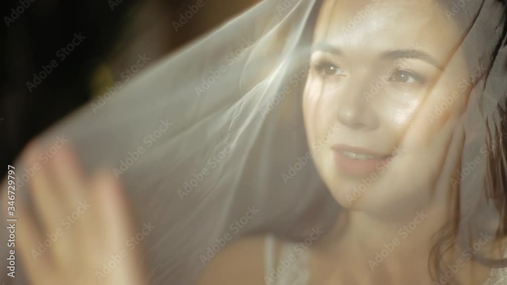 Morning of happy young european bride in wedding veil, slowly pulling ...