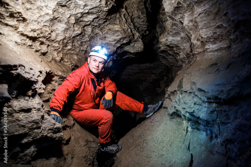 Foto de Man walking and exploring dark cave with light headlamp ...