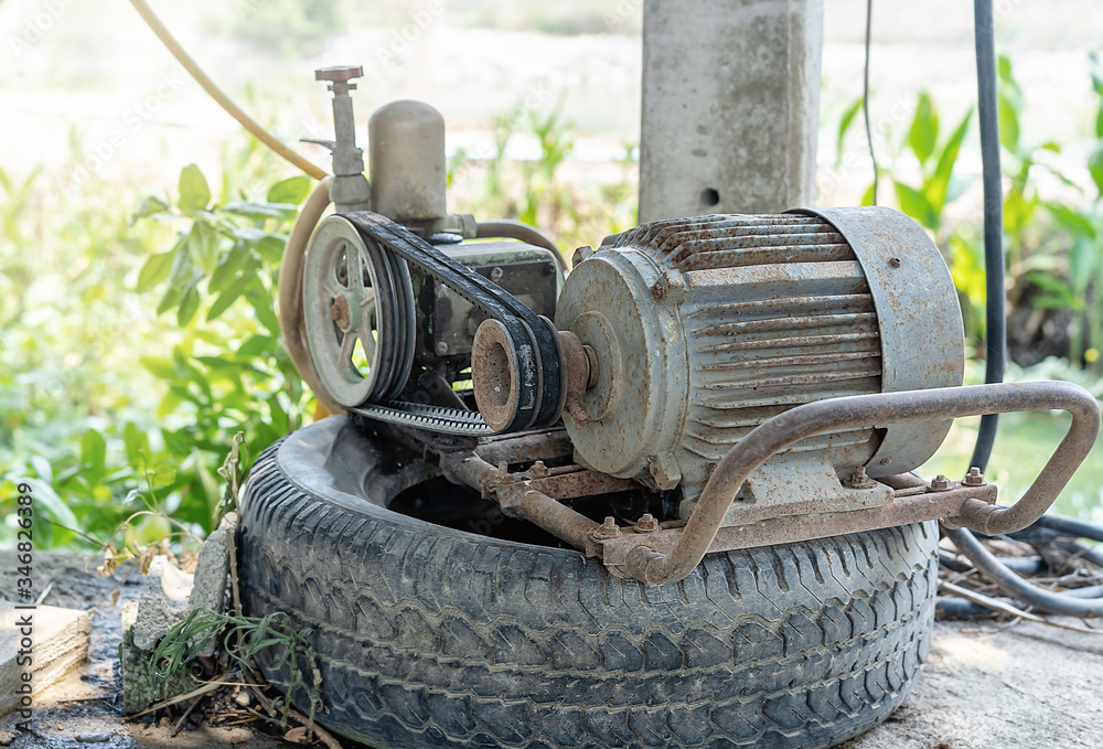 Old electric motor pumping machine on a black car wheel using for ...