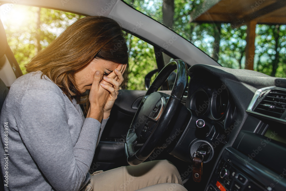 Shocked young woman driver had a car crash. Headache after the impact ...