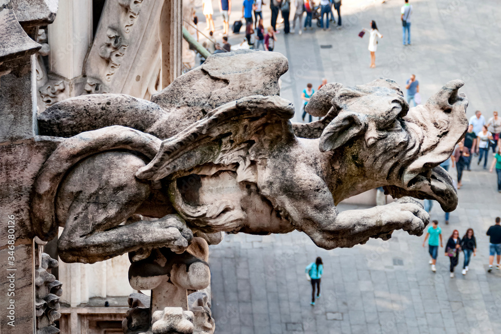 Close up gargoyle statue decorating the roof of famous Duomo di Milano ...