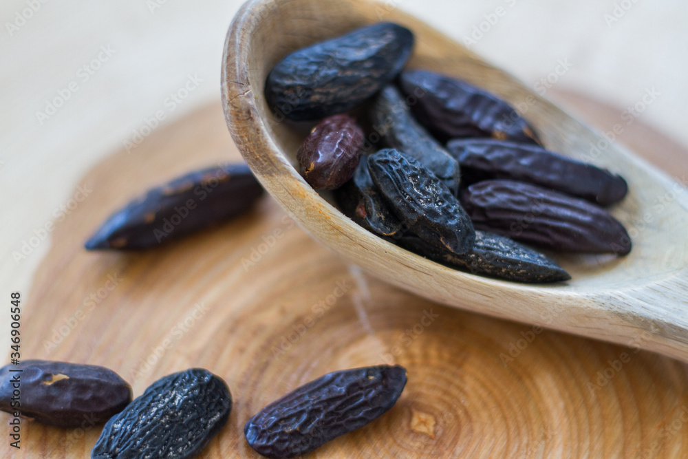 Tonka beans isolated with wooden spoon, seads from dipteryx odorata ...