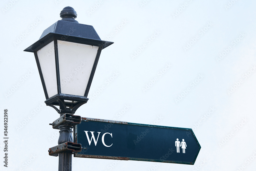 Public toilet, wc or restroom sign on vintage street light pillar ...
