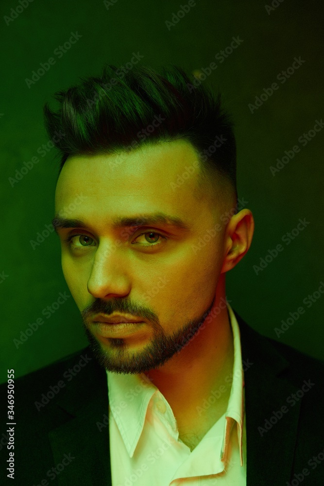 Portrait of handsome young man against studio background. Perfect hairstyle, modern stylish ...