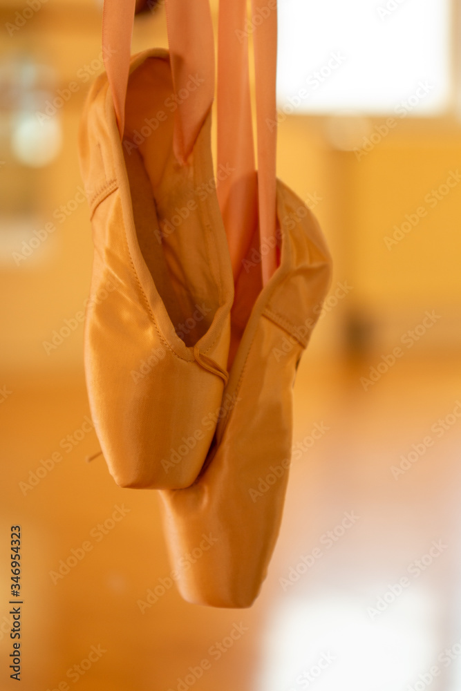 Pointe shoes - ballet shoes hang on ballet bar in dance studio with ...
