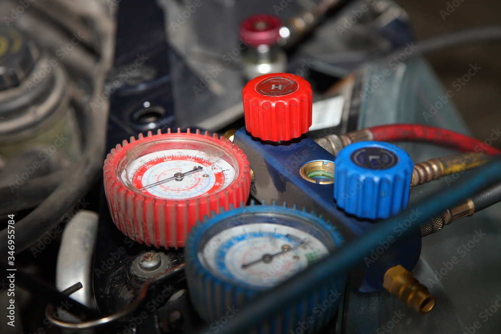 Car A/C red and blue manometers and valves close up under the hood of ...