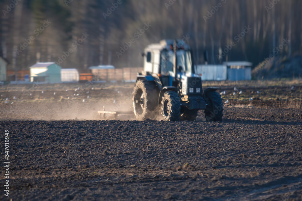 Foto de Tractor with a disc harrow system harrows the cultivated farm ...