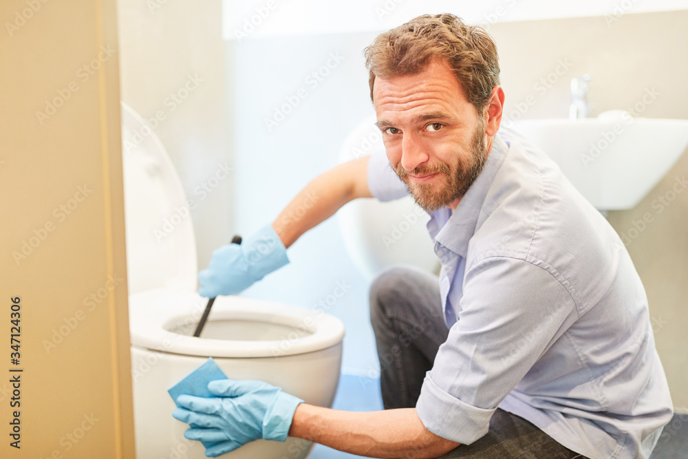 Hausmann putzt das Klo oder WC im Badezimmer Stock Photo | Adobe Stock