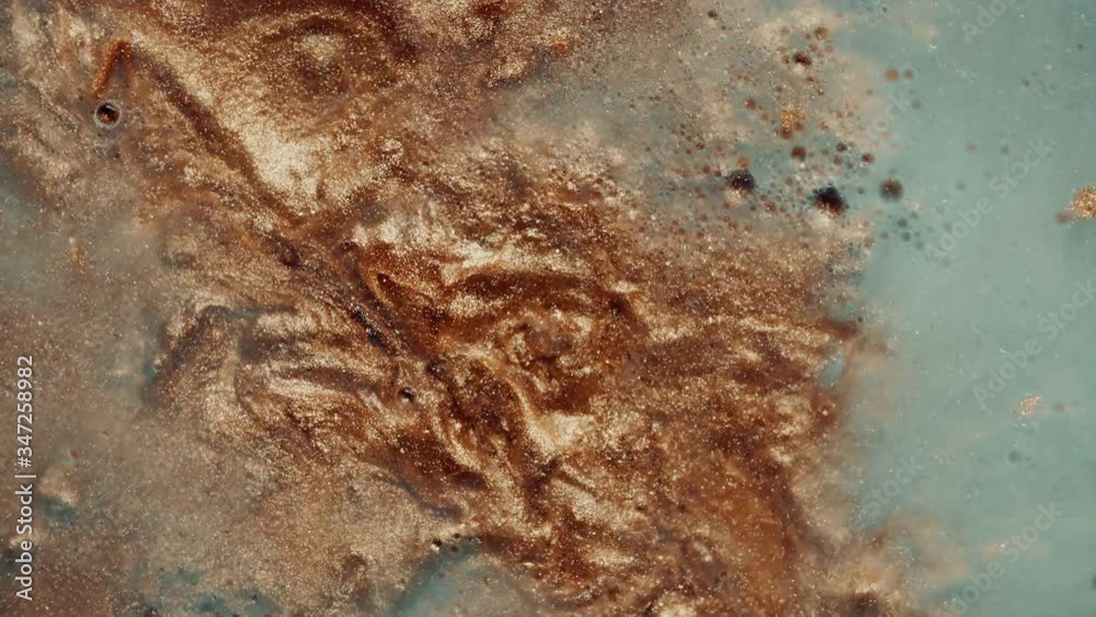 Liquid gold and bronze paint flow mix in fantastic design and patterns ...