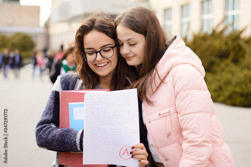 Smiling students happy to receive good marks grades of examination ...